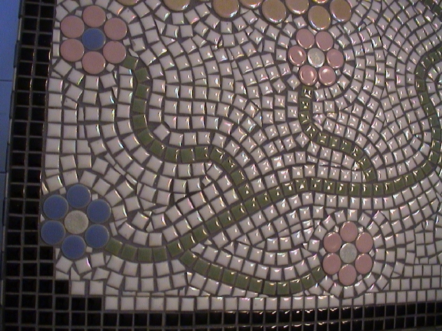 Close up of the corner of a mosaic table created with tiny tile and ...